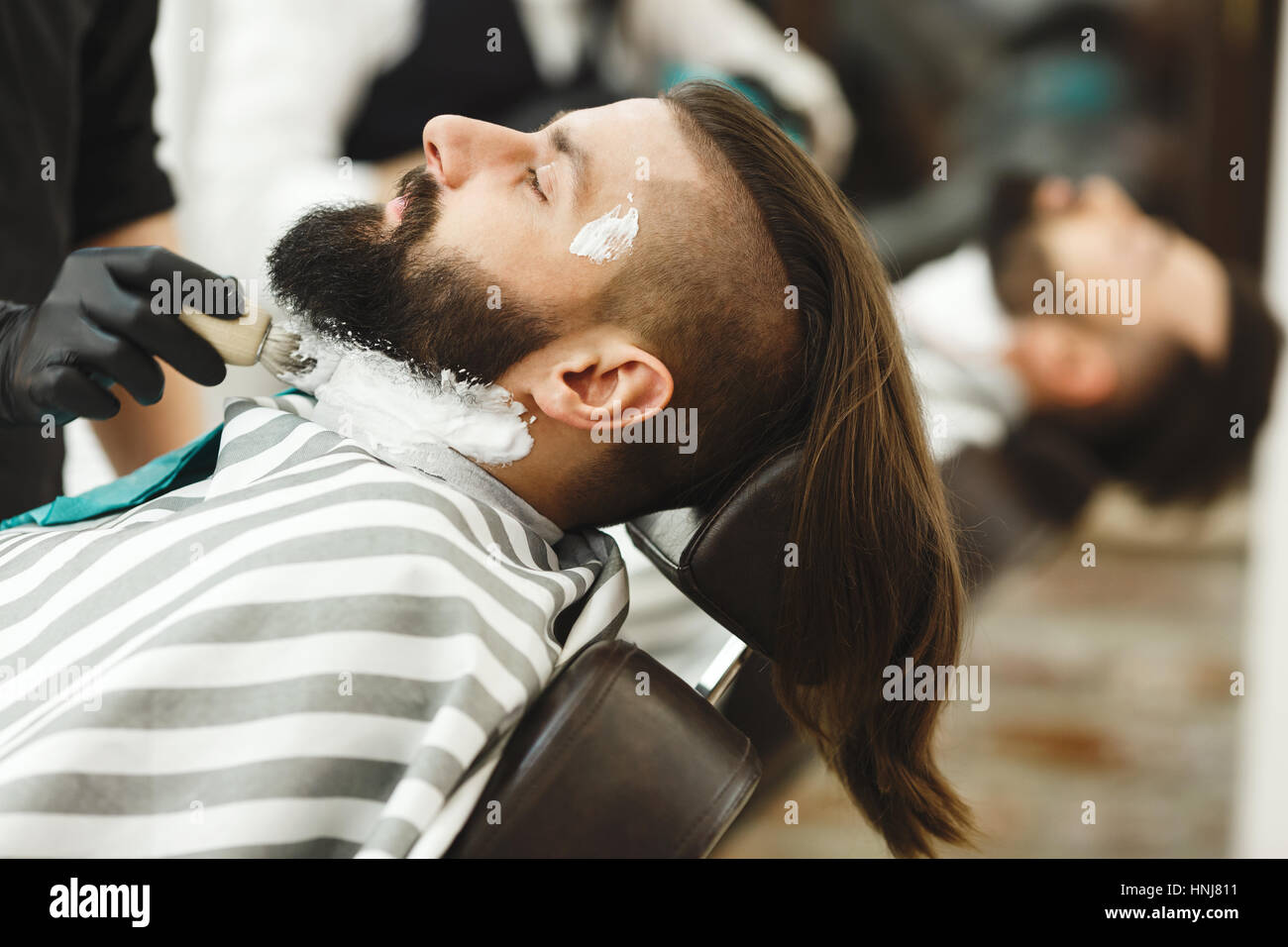 Barber making a beard form for client Stock Photo - Alamy