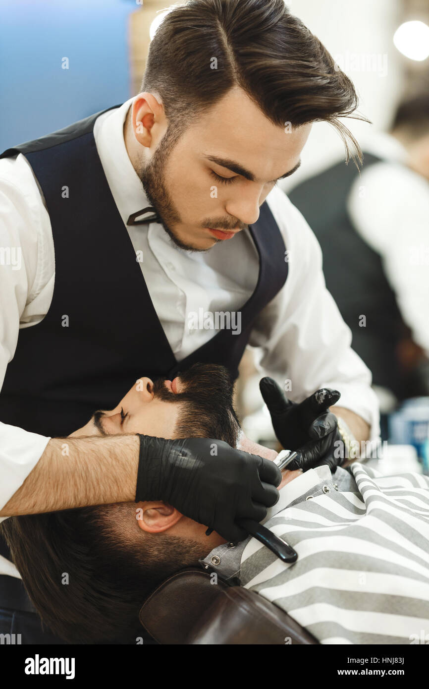 Barber making beard form for man Stock Photo - Alamy