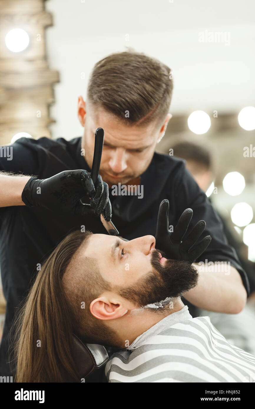Barber making beard form for man Stock Photo - Alamy