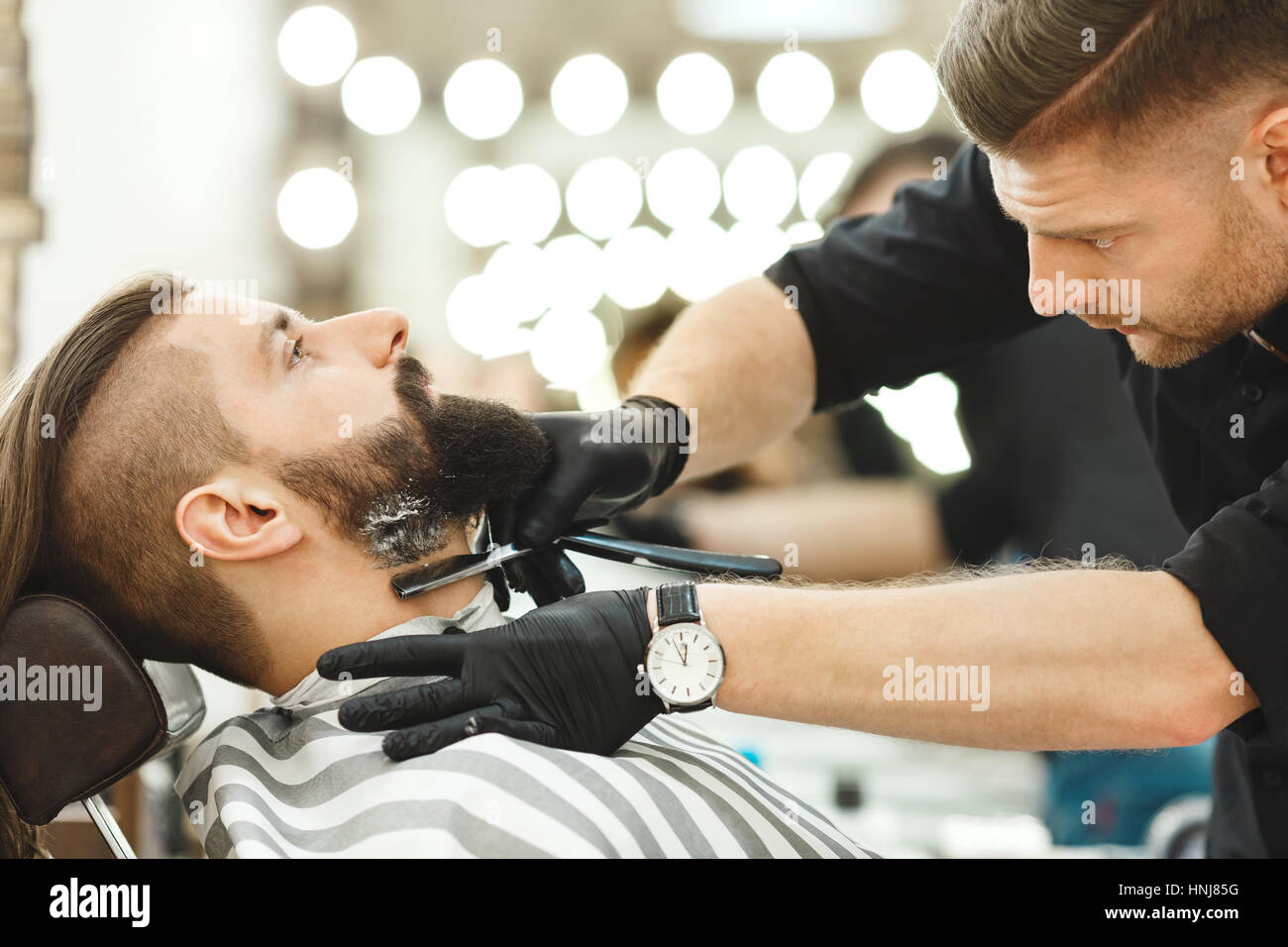 Barber making beard form for man Stock Photo - Alamy