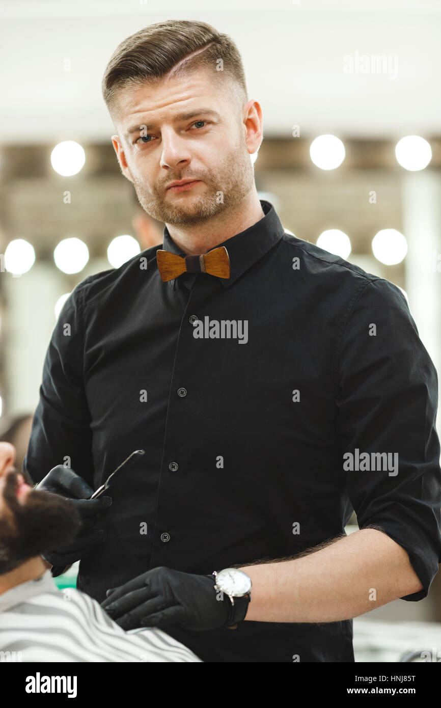Barber making beard form for man Stock Photo - Alamy