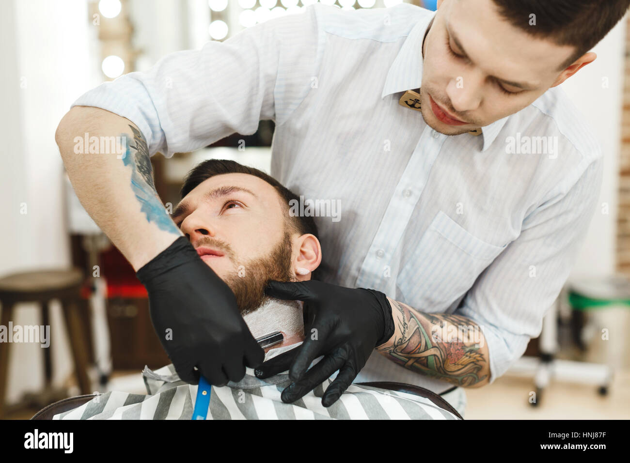 Barber making beard form for man Stock Photo - Alamy