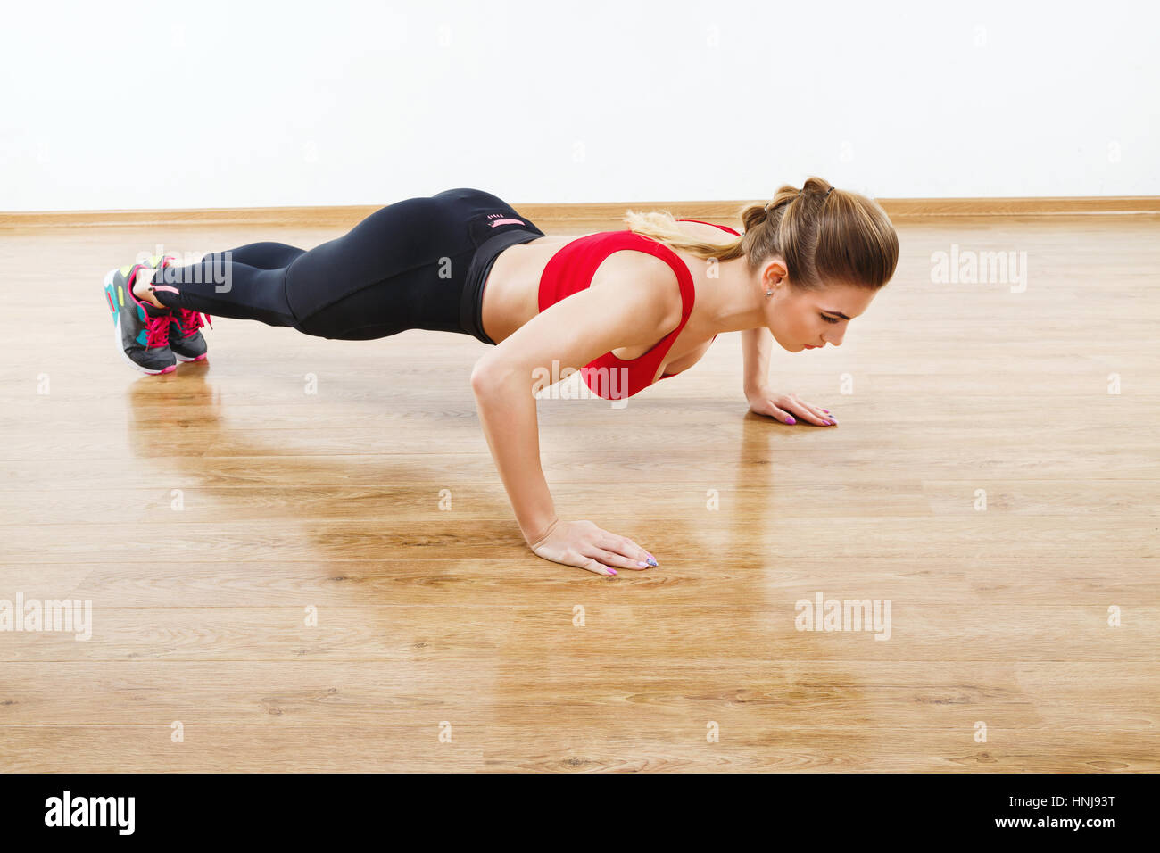 Attractive fit girl doing physical exercises at gym Stock Photo - Alamy