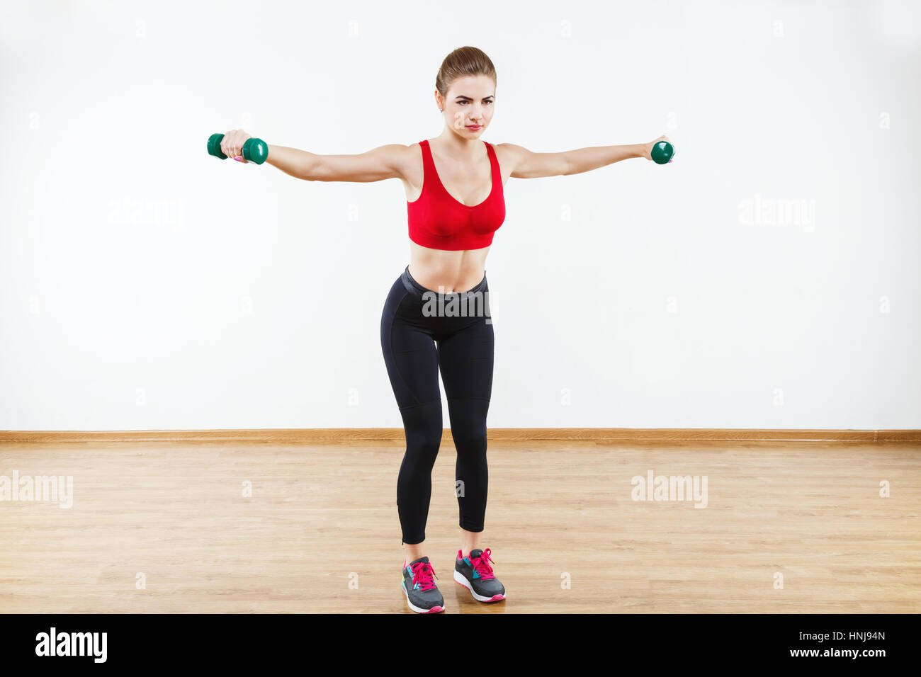 Attractive fit girl doing physical exercises at gym Stock Photo - Alamy
