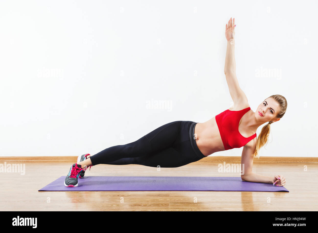 Attractive fit girl doing physical exercises at gym Stock Photo - Alamy