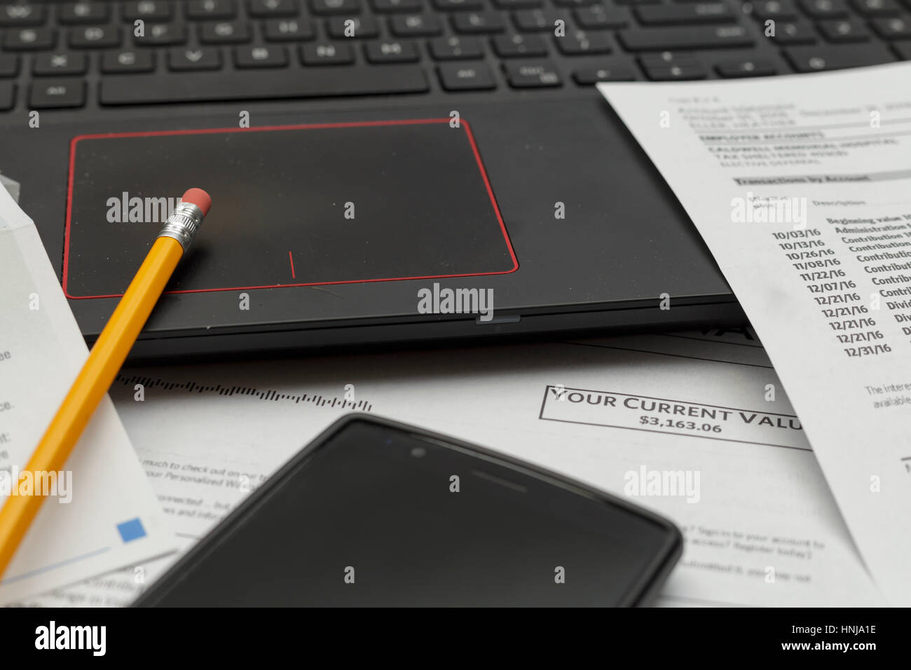 investment paperwork with computer and smartphone Stock Photo - Alamy