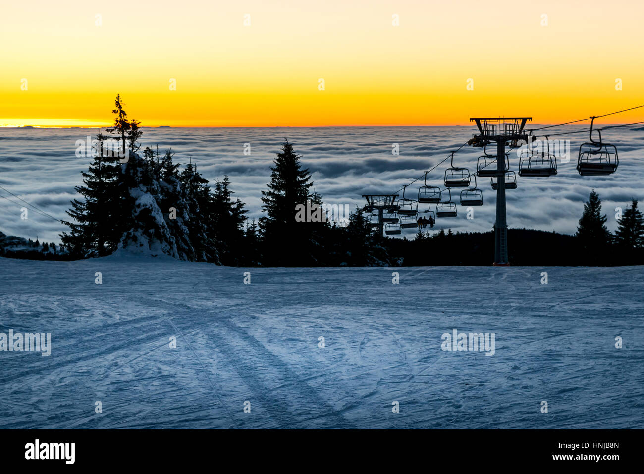 Chair ski lift with skiers silhouettes at sunset Stock Photo - Alamy