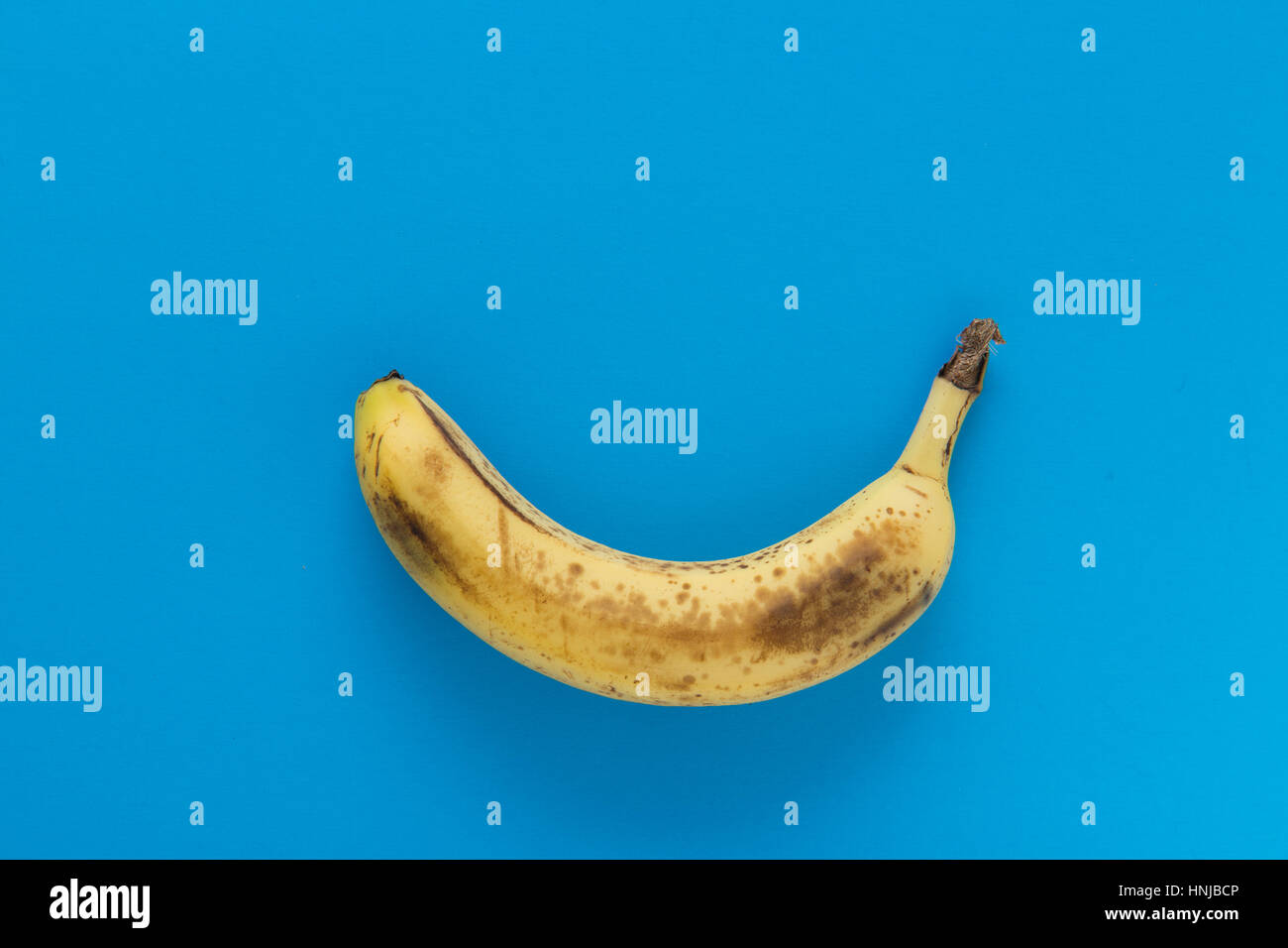 Slightly overripe banana on a light blue background Stock Photo - Alamy