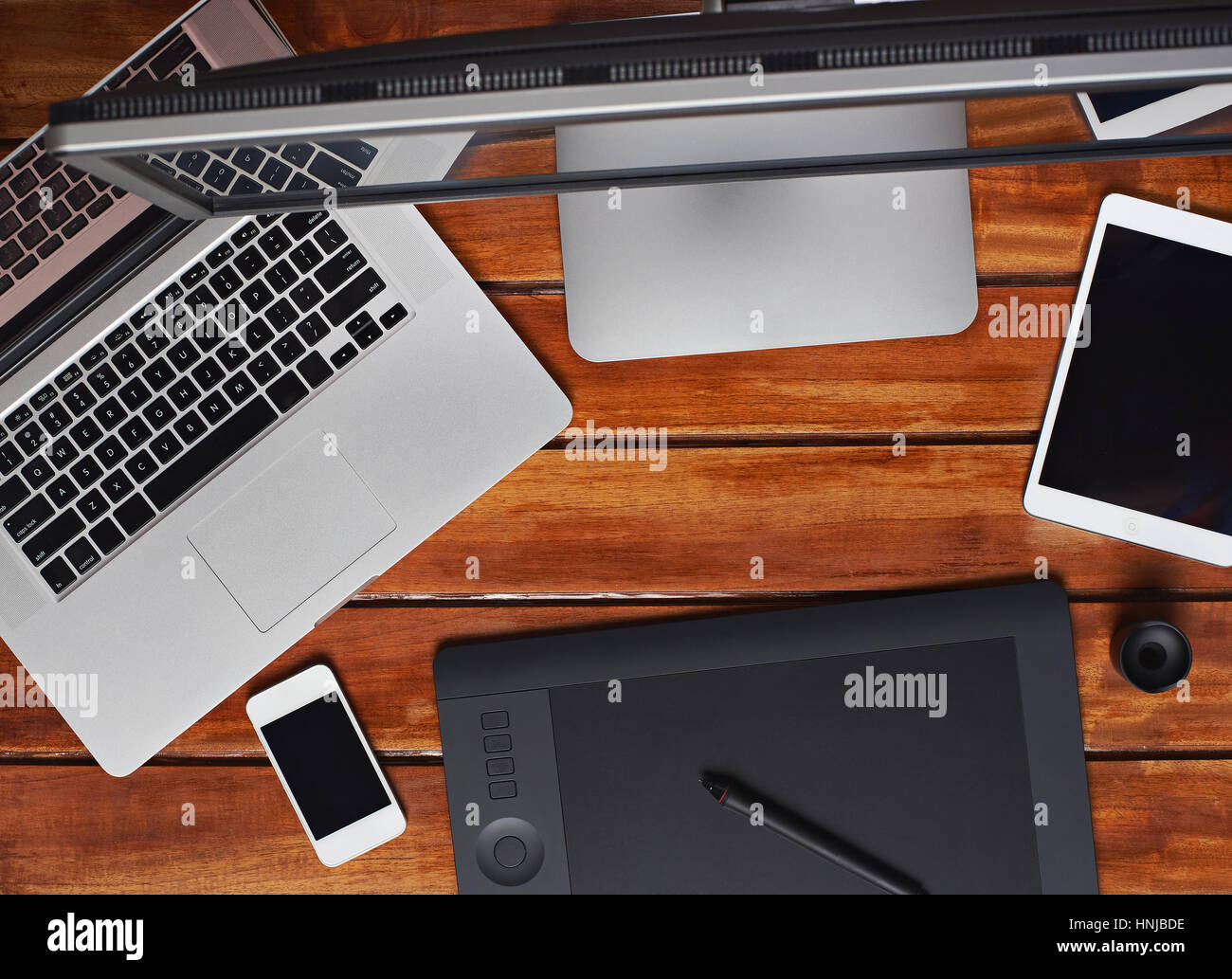 working space of retoucher on wooden table with gadgets computer ...