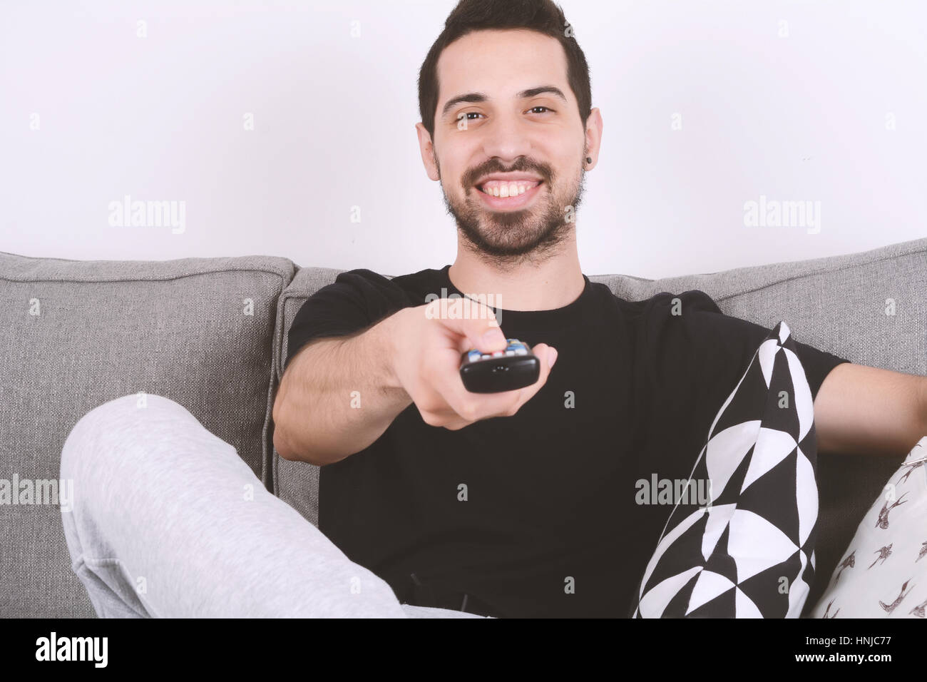 Attractive young man watching tv and relaxed on couch. Indoors Stock ...