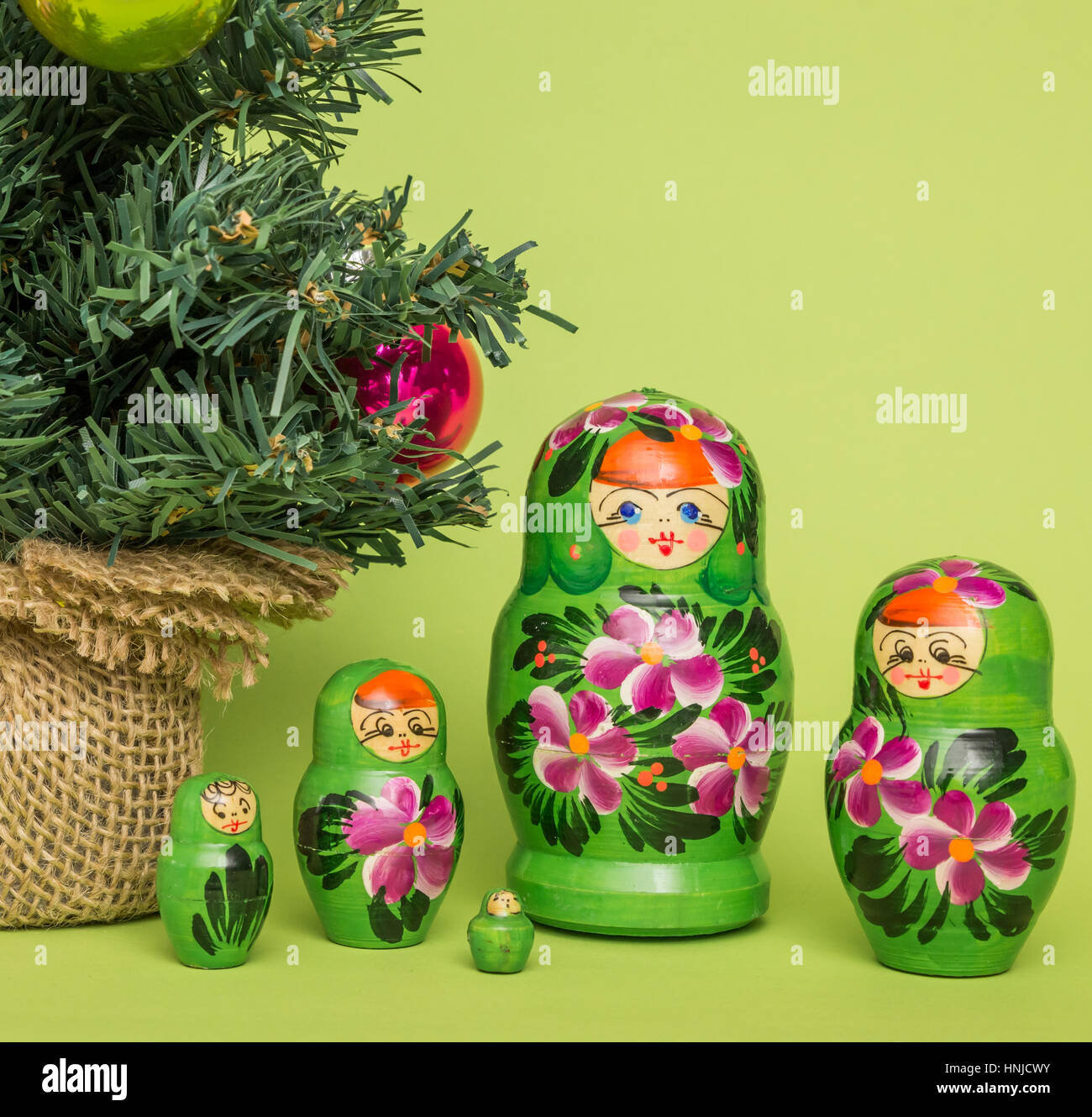 Russian wooden dolls around a Christmas tree in a square composition ...