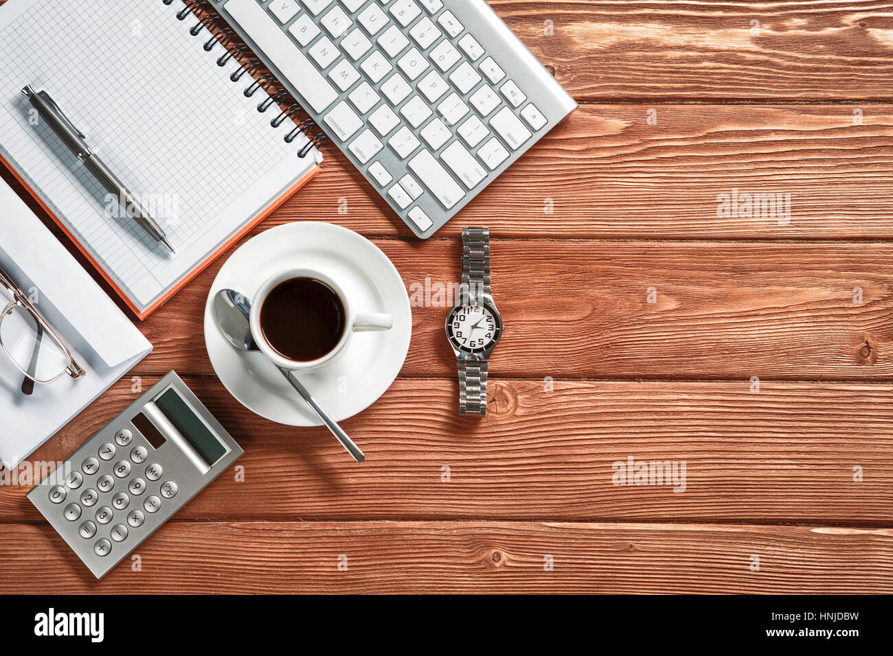 Top view of Office table with keyboard cup watch notebook and ...