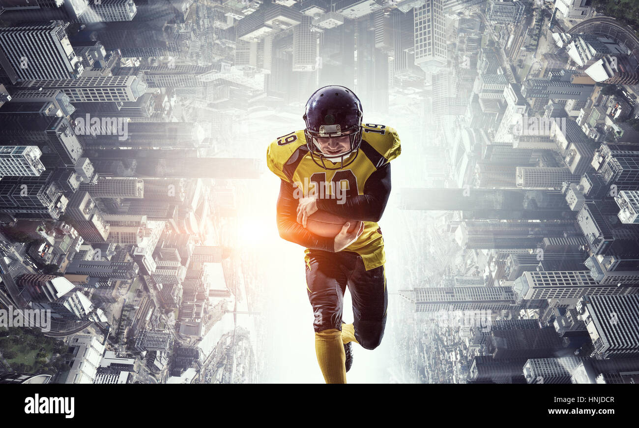 Confident American football player running with ball in hands Stock ...