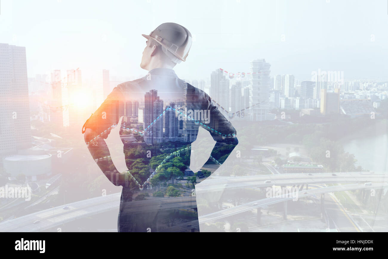 Back view of builder man looking at modern city Stock Photo - Alamy