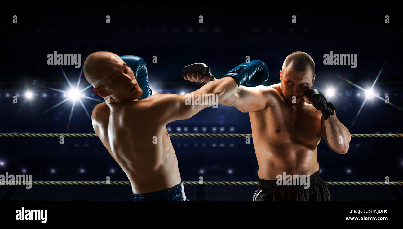 Two professional boxers fighting at sport arena. Mixed media Stock ...