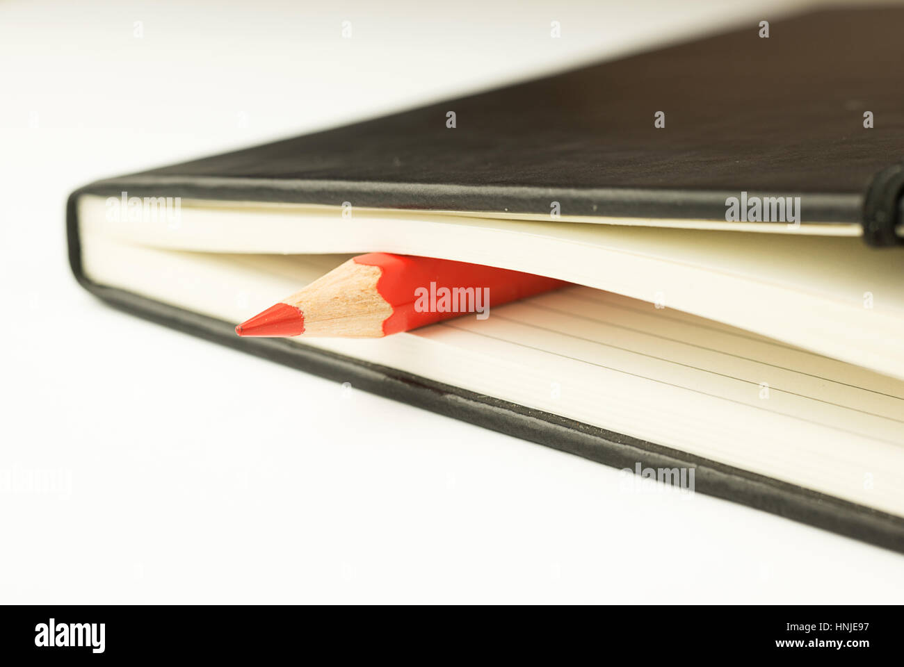 Colored pencil is inside the close notebooks Stock Photo - Alamy