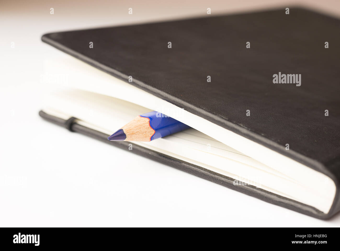 Colored pencil is inside the close notebooks Stock Photo - Alamy