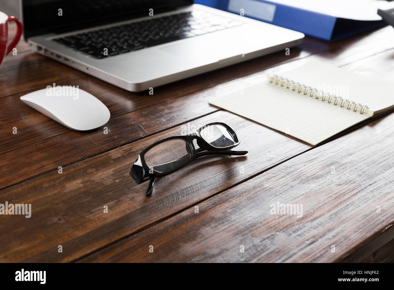 eyeglasses, laptop computer and notepad on wooden office desk Stock ...