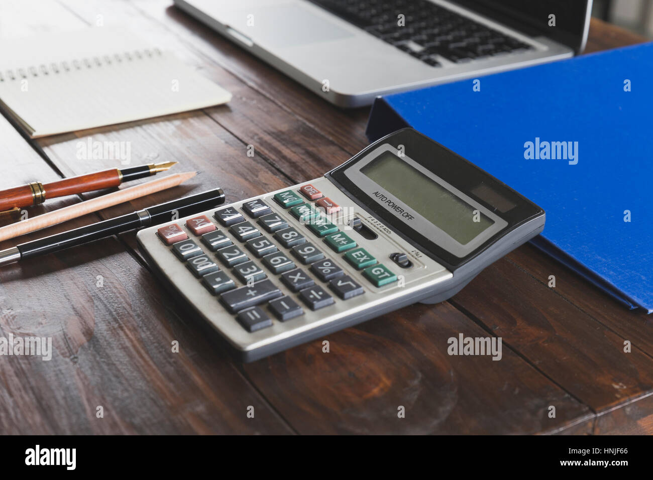 calculator, laptop computer, pen and notepad on wooden office desk ...