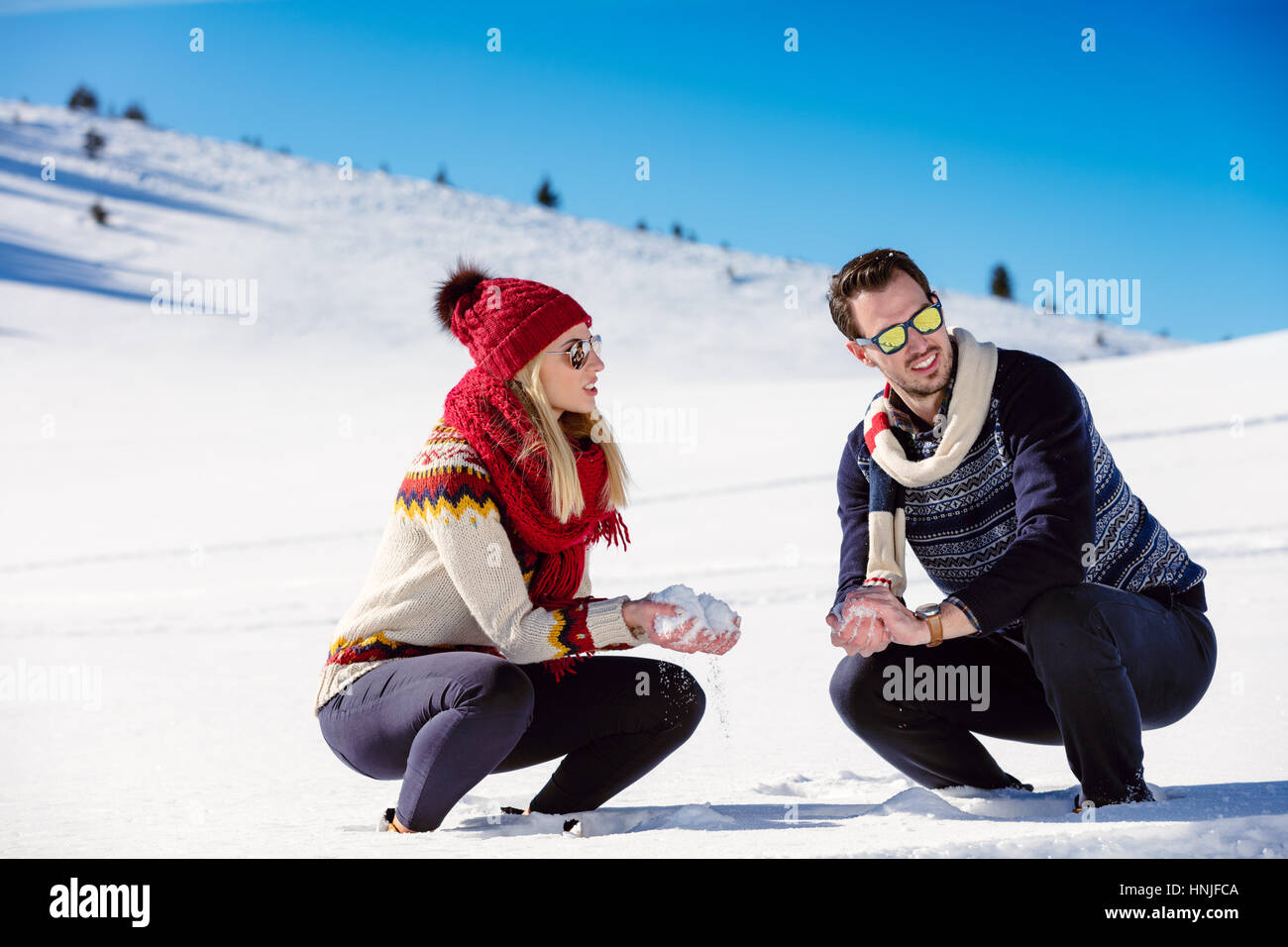 Snowball fight. Winter couple having fun playing in snow outdoors ...