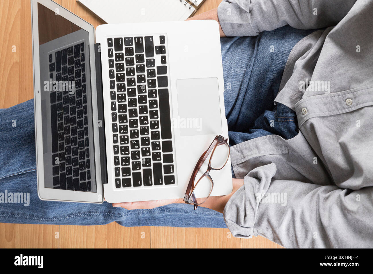 man sitting on floor with laptop computer and eyeglasses - top view ...