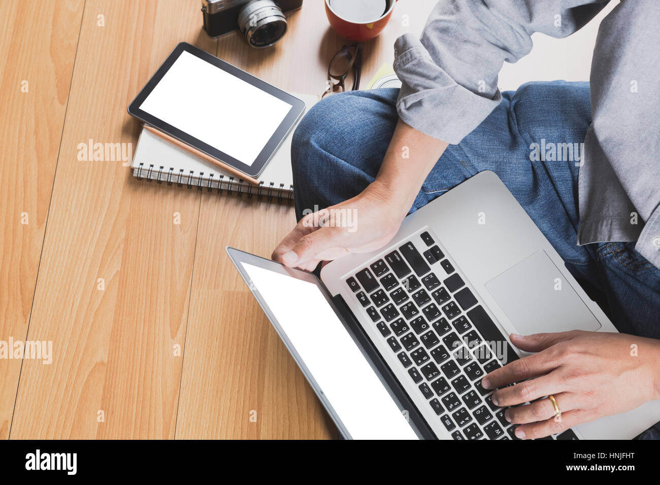 man sitting on floor with laptop computer, coffee cup and tablet - top ...