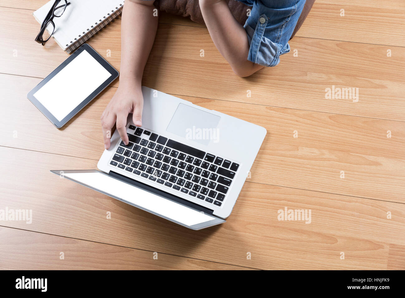 woman lying on wooden floor with computer notebook and tablet Stock ...