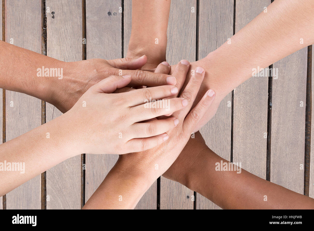 people put hand together on wooden table for use as teamwork, unity ...