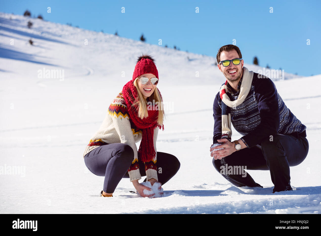 Snowball fight. Winter couple having fun playing in snow outdoors ...
