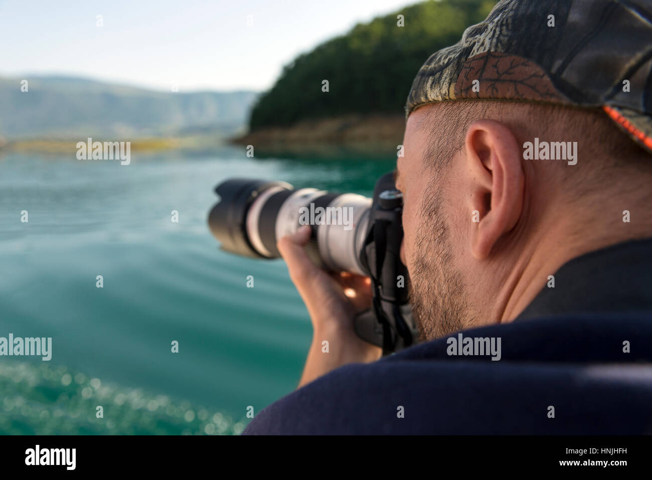Photographer in nature taking pictures to a beautiful lake Stock Photo ...