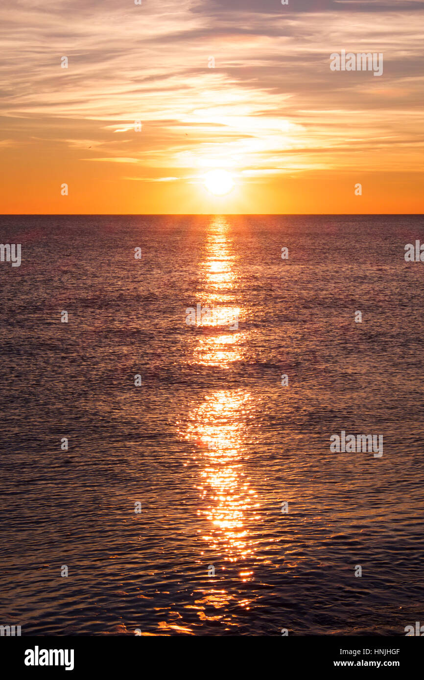 low sunset sun with sunbeam in the centre casting long highlight from ...