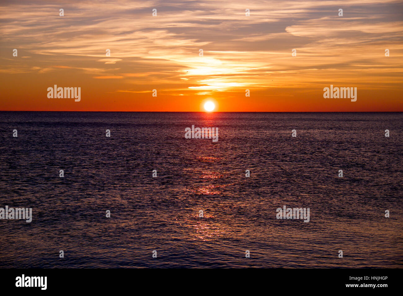 low sunset sun with sunbeam in the centre casting long highlight from ...