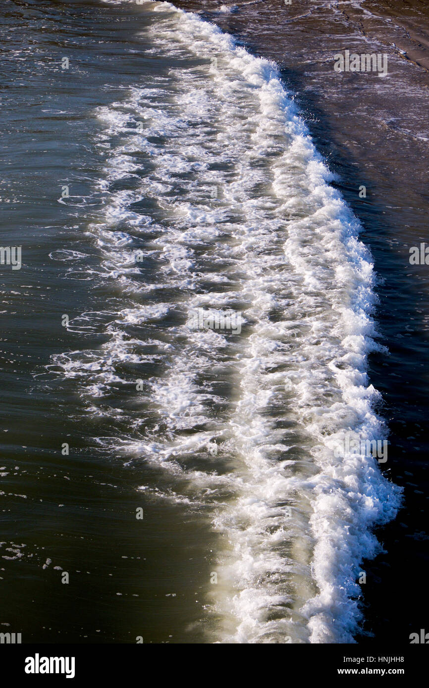 small wave breaking photographed from above, breaking wave running in a ...