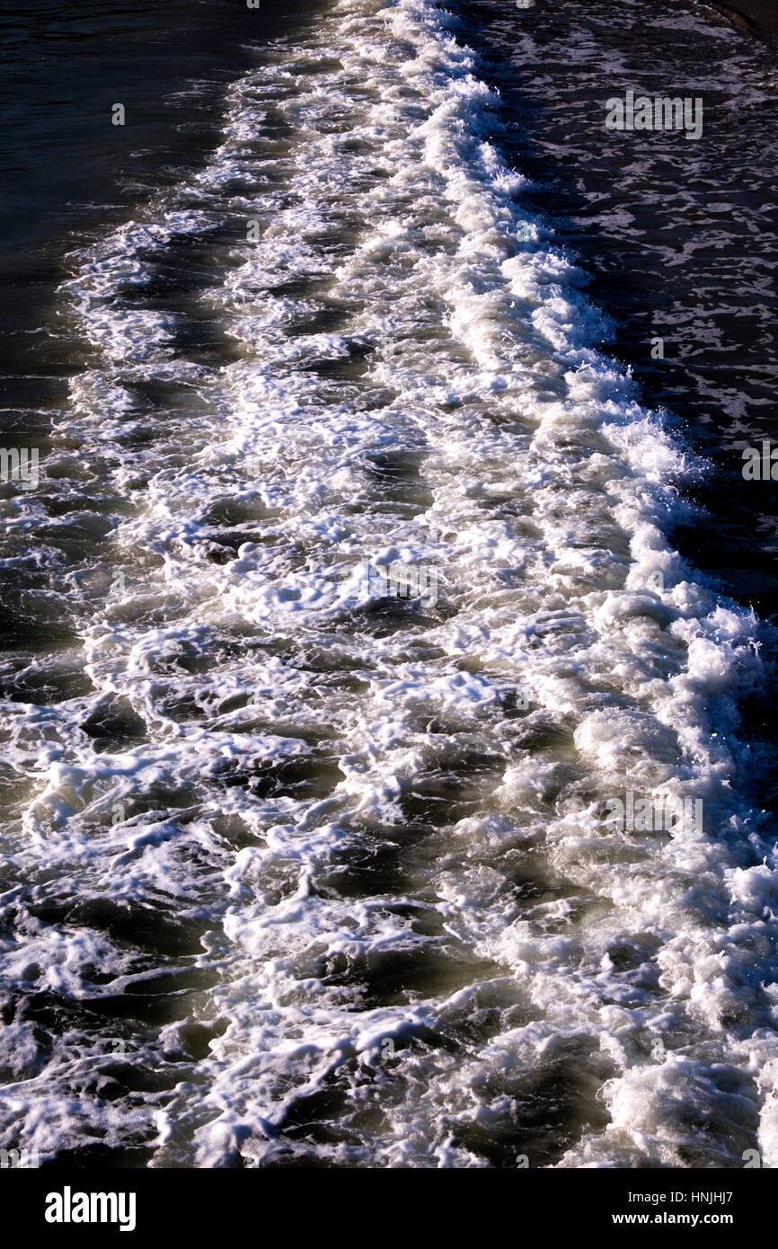 small wave breaking photographed from above, breaking wave running in a ...