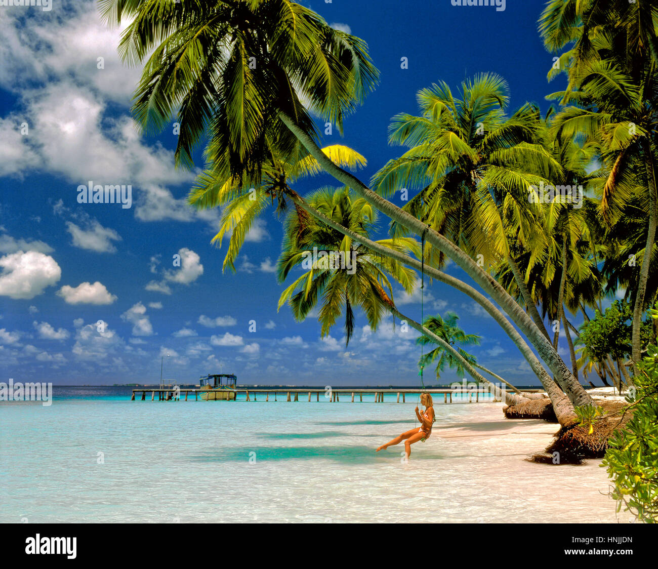 Paradise, Girl on swing under palm trees, Kuda Bandos Island, North ...