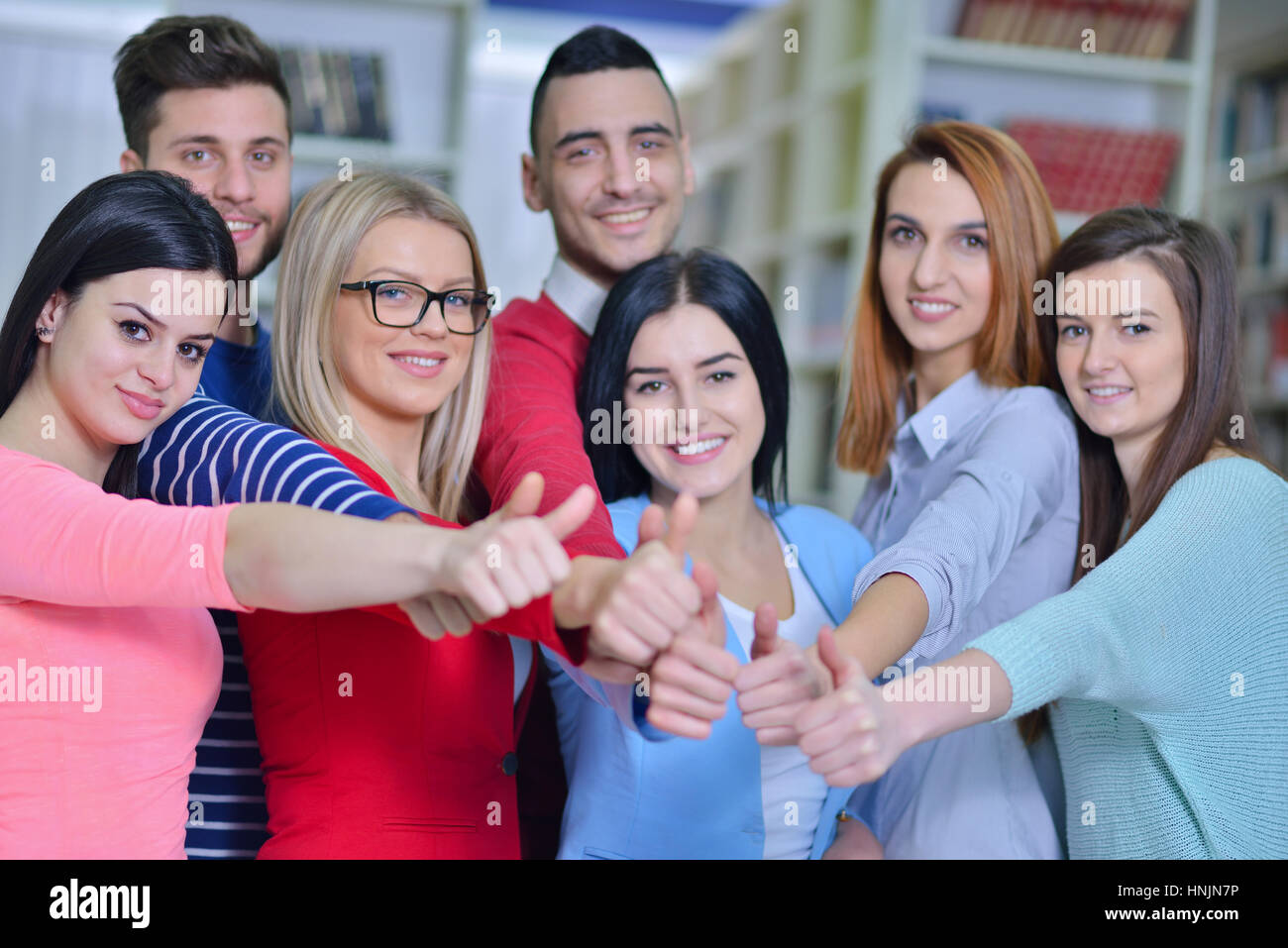 Cheerful group of students smiling at camera with thumbs up, success ...