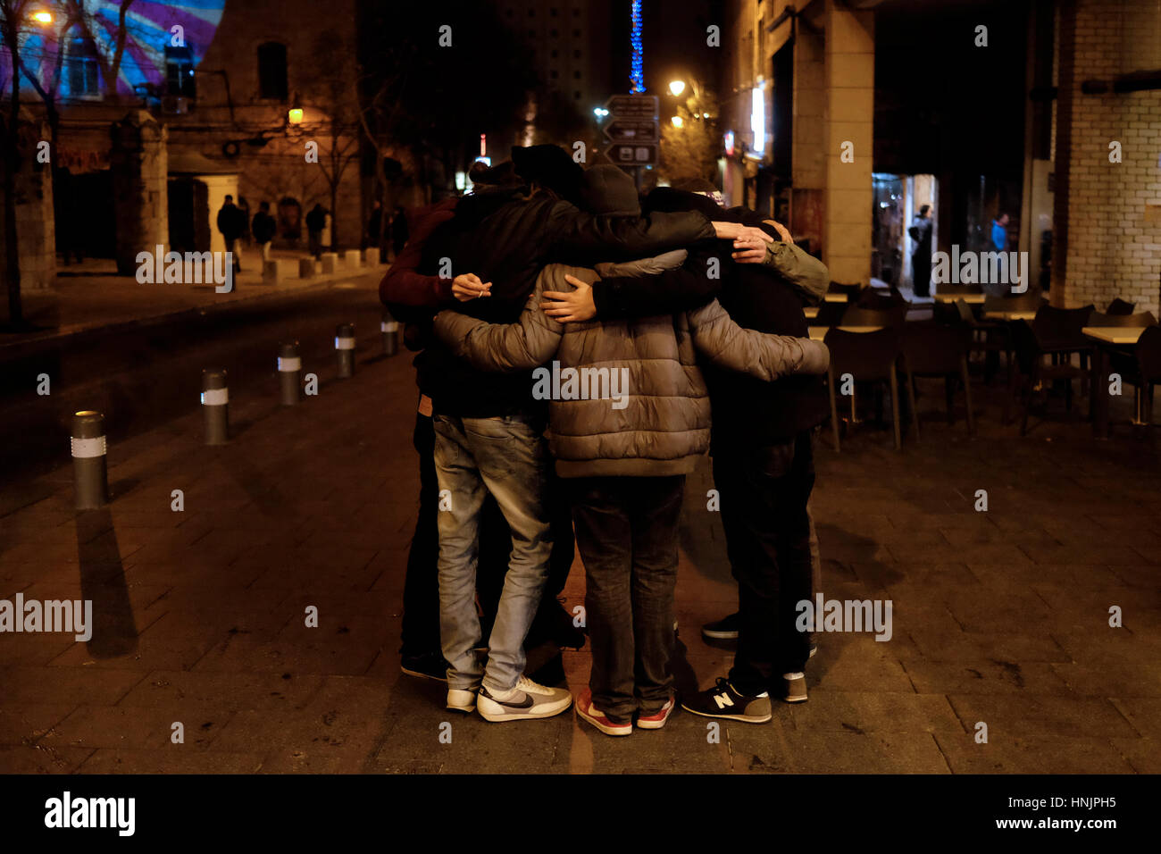 A group of young Israelis hugging each other in circle in the street ...