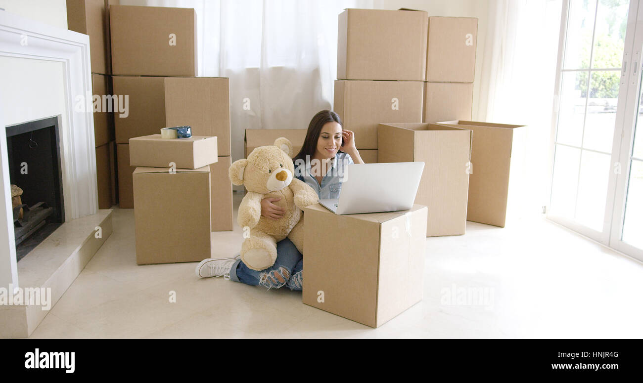 Smiling young woman catching up on her social media on a laptop ...