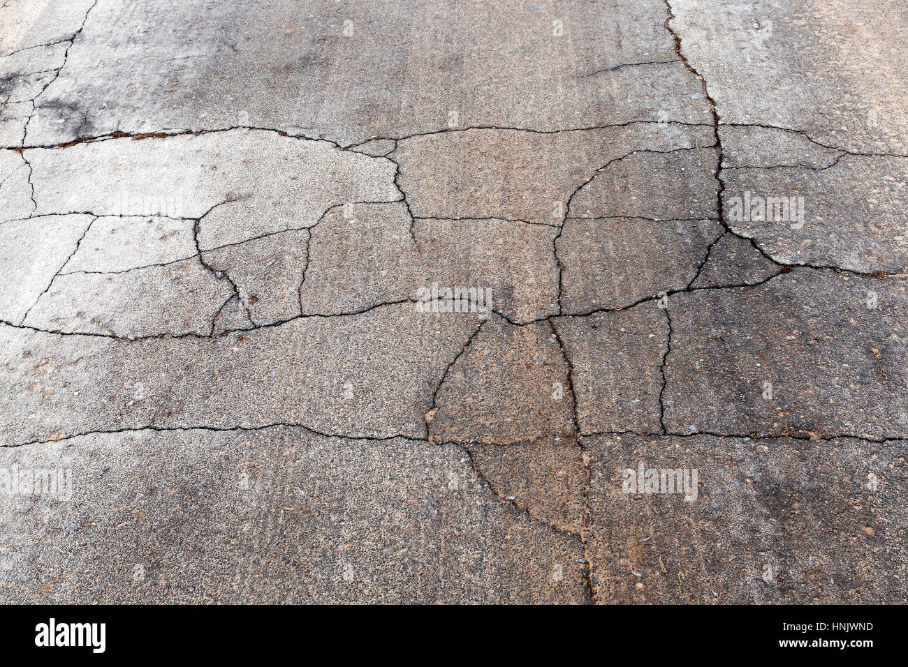 a very bad crumbling asphalt road with holes and cracks. Photo taken ...