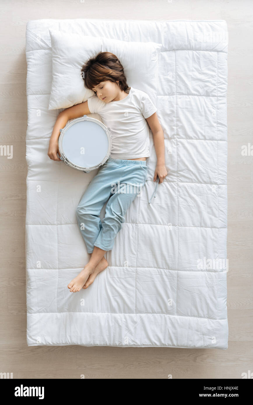 Exhausted lovely boy napping after practicing Stock Photo - Alamy