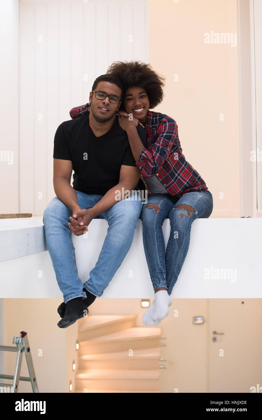 Happy young African American couple having break during moving to new ...