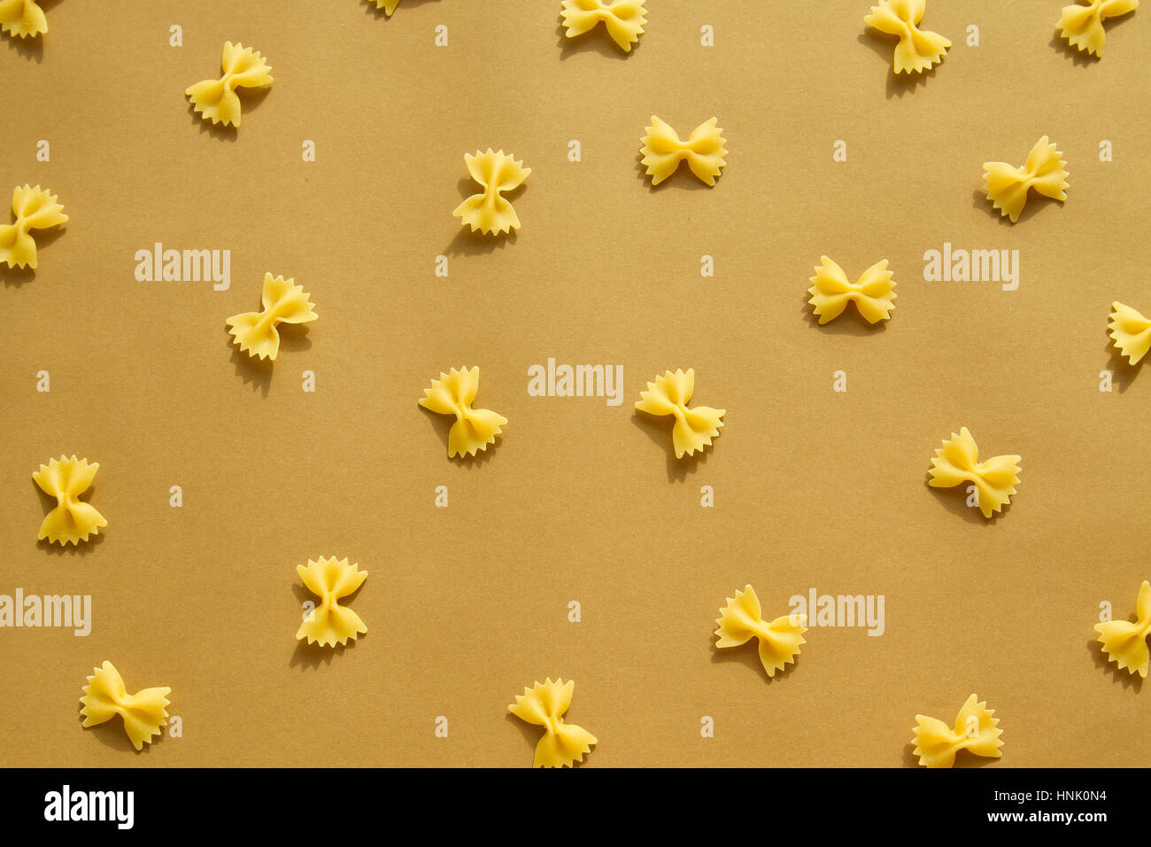 Pasta bow and spiral shape on brown background Stock Photo - Alamy