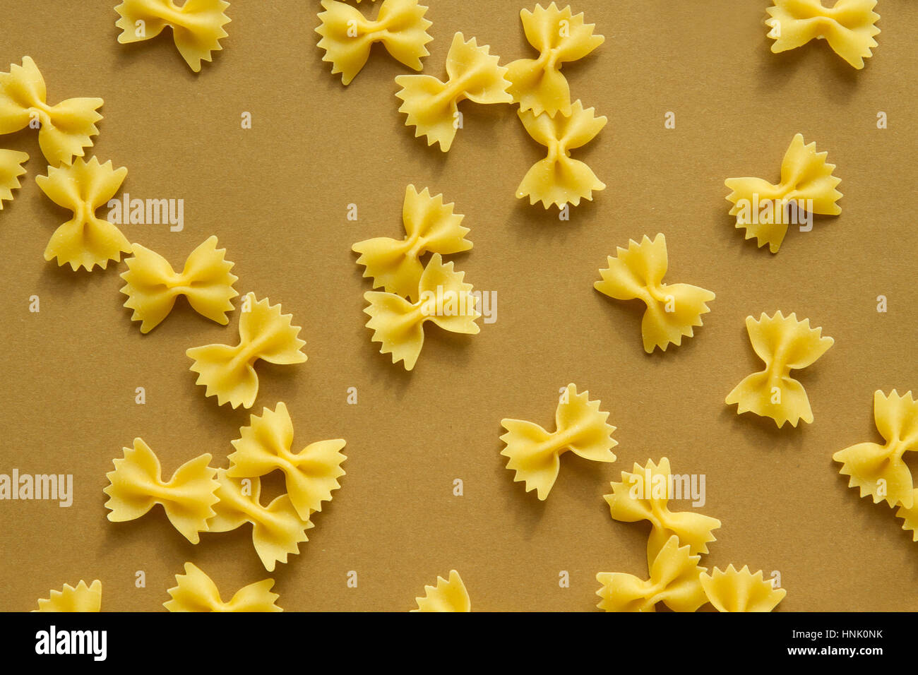 Pasta bow shape on brown background Stock Photo - Alamy