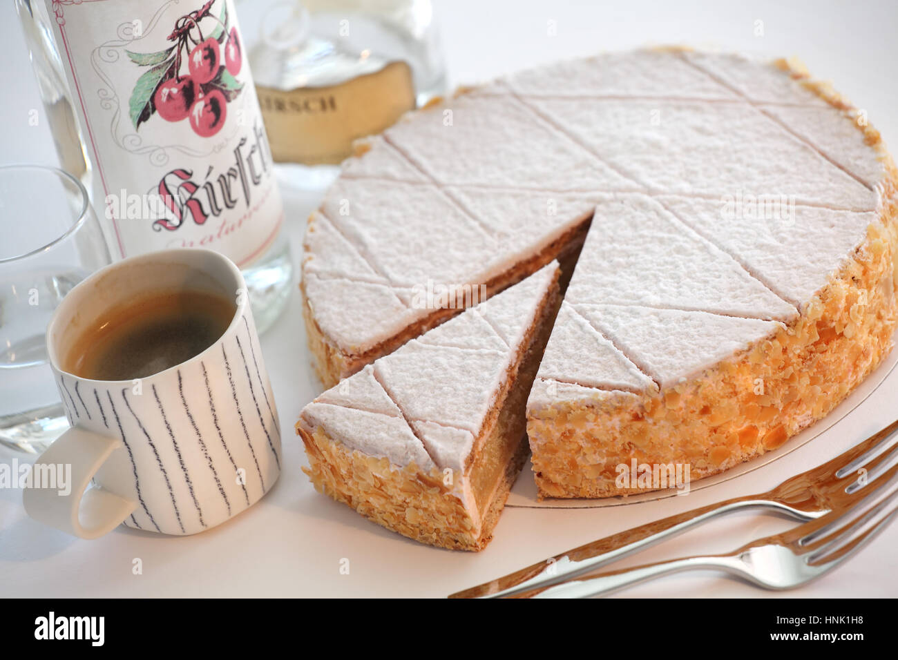 Photo of a Zuger Kirschtorte, with bottles of kirsch schnapps and ...