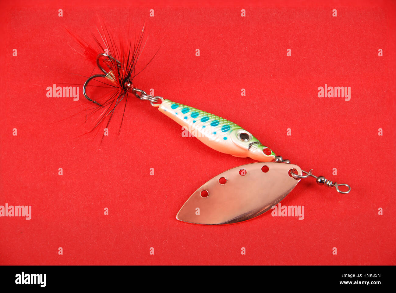 Fishing lure in the shape of a fish with a hook on red background Stock ...