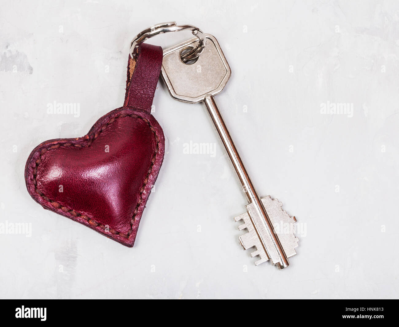 big key with red leather heart shape keychain on concrete plate Stock ...