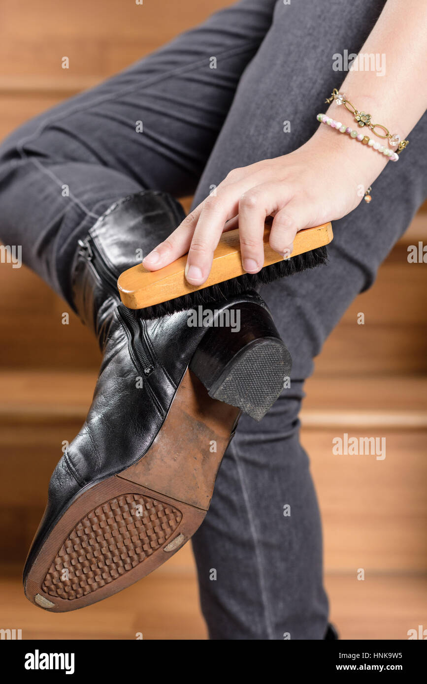young woman cleaning her boots Stock Photo - Alamy