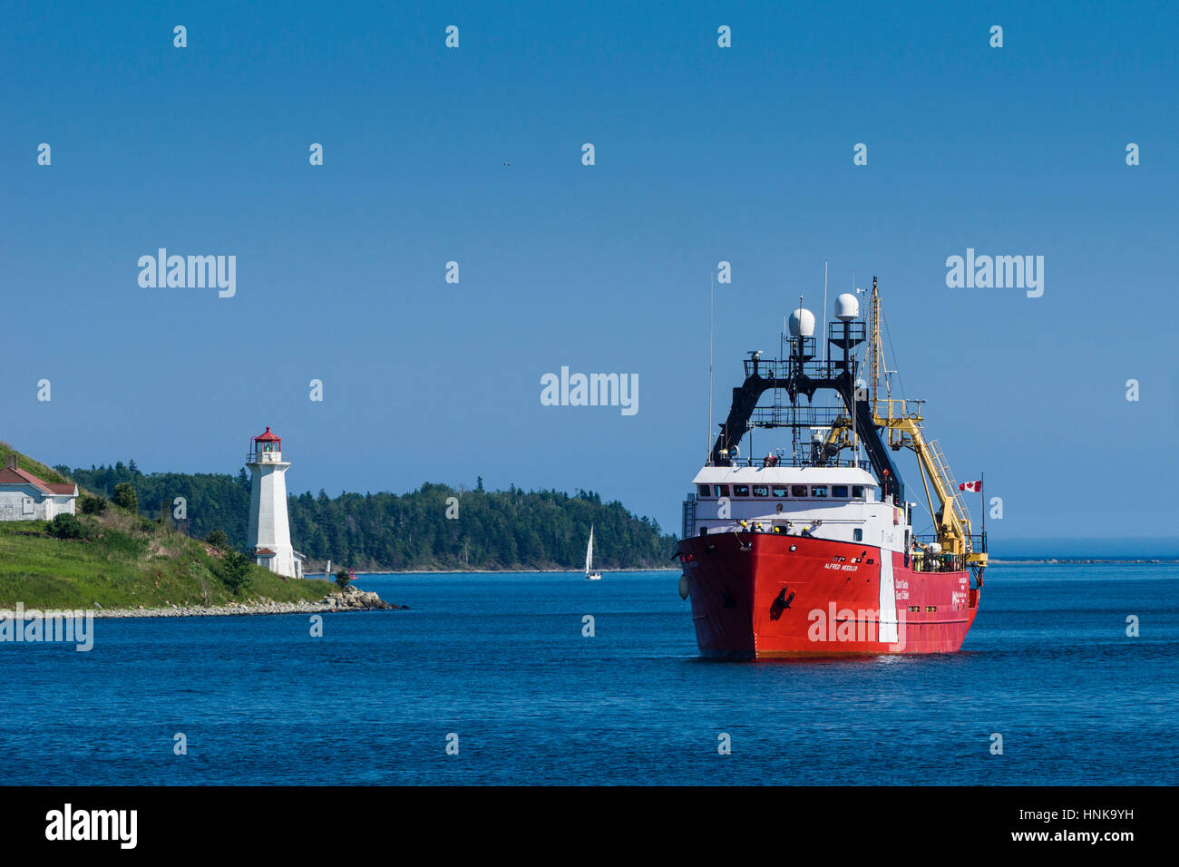 Canadian Coast Guard Ship (CCGS) "Alfred Needler" passes a lighthouse ...
