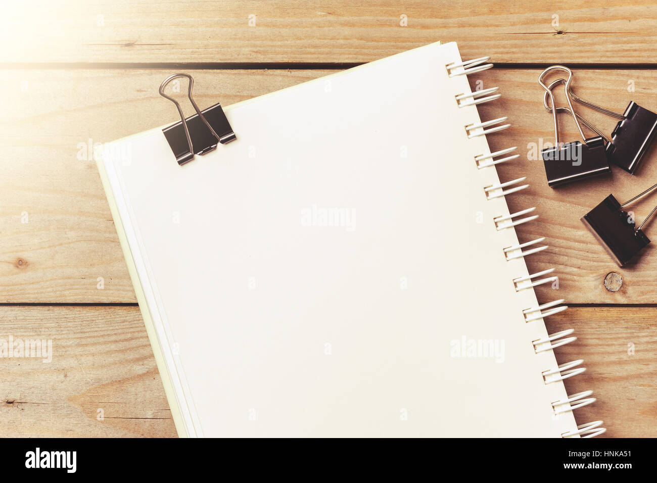 black binder clips and notebook on wooden plank Stock Photo - Alamy