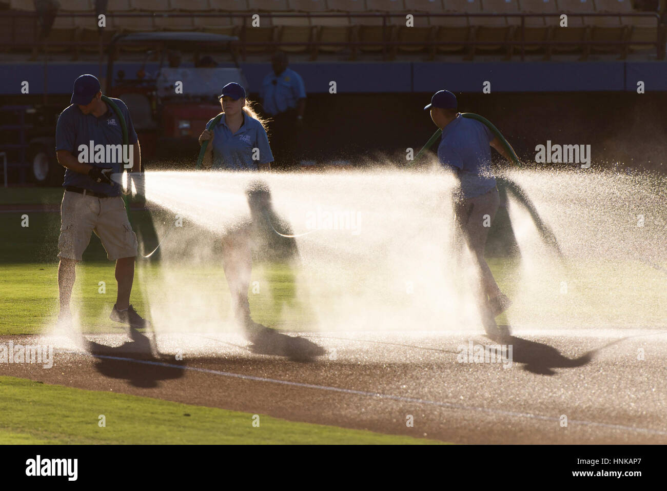 Members of the field crew spray the infield with water prior to a Las ...